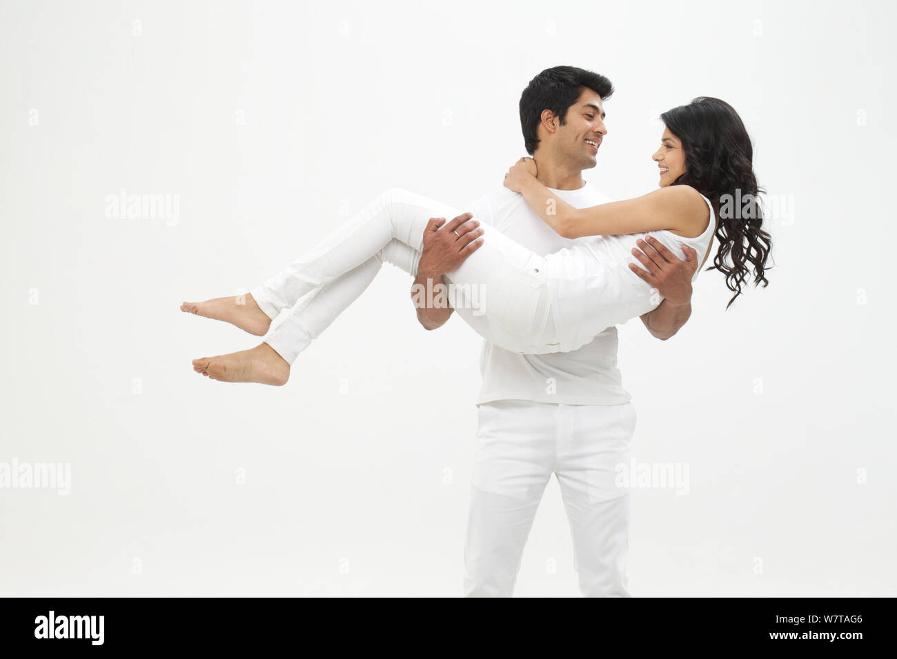 Young man carrying his girlfriend isolated on white background Stock ...