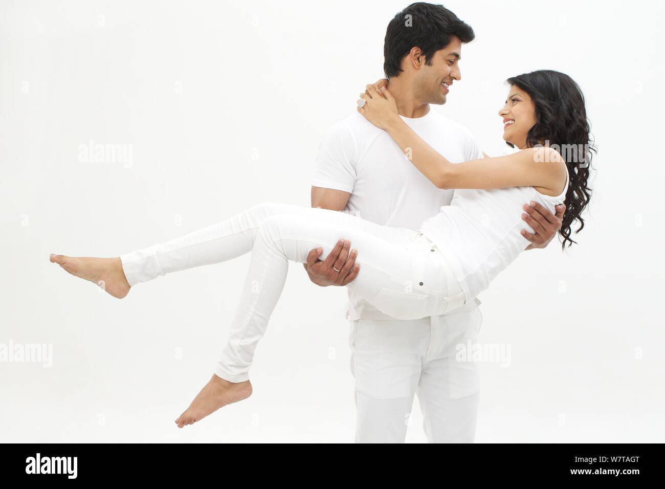 Young man carrying his girlfriend isolated on white background Stock ...