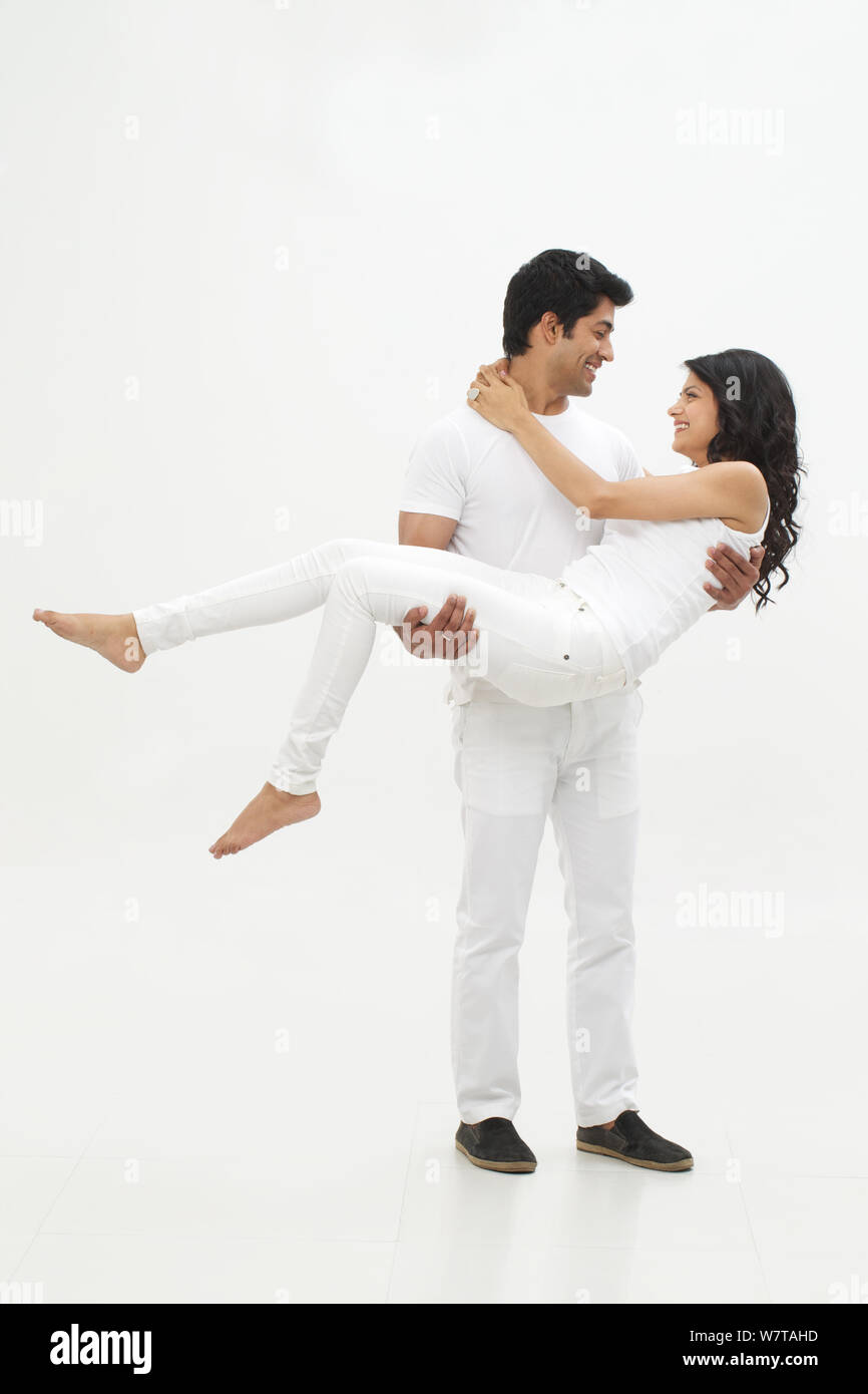 Young man carrying his girlfriend isolated on white background Stock ...