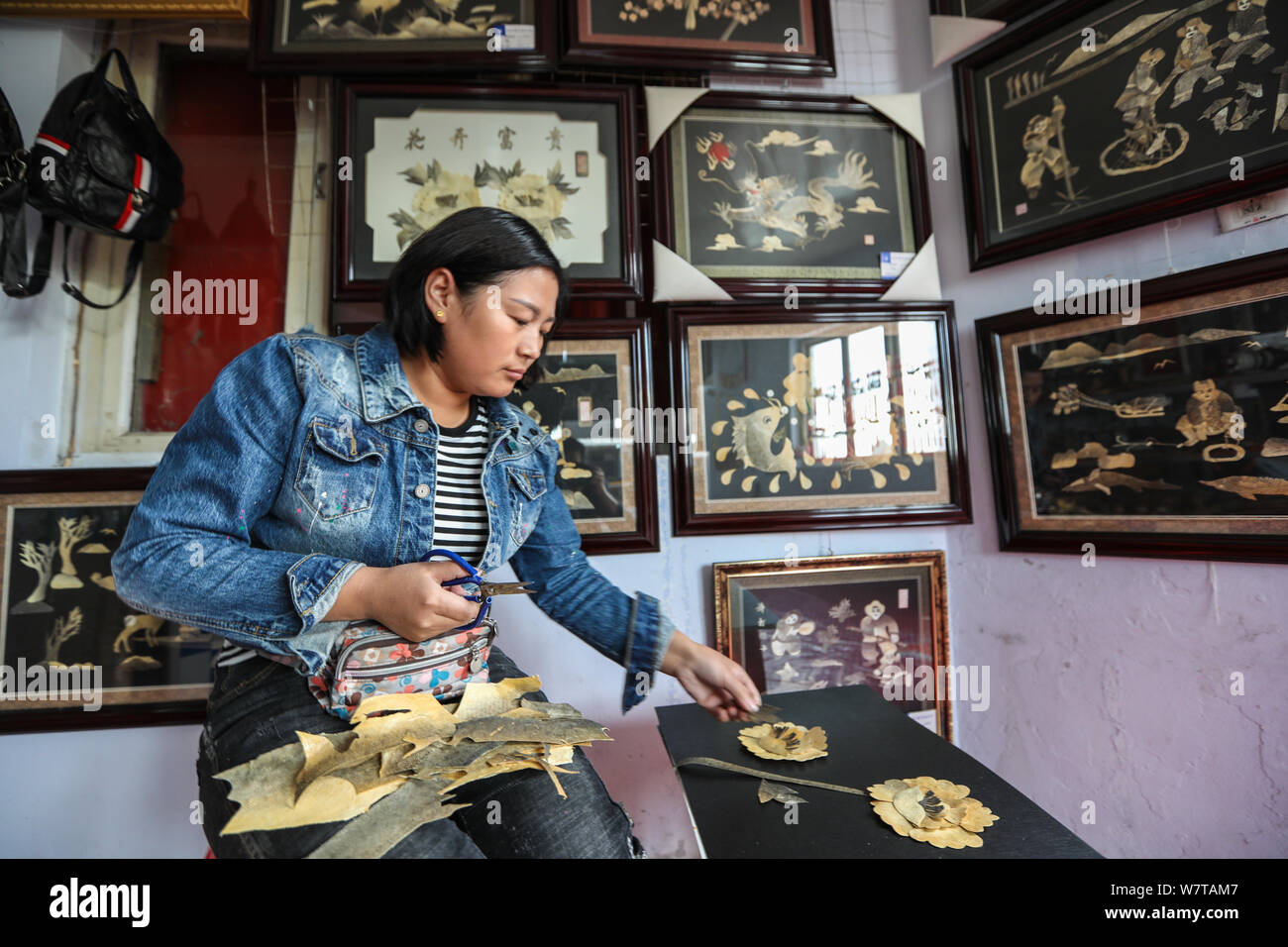 Chinese folk artist Wang Jinfeng makes a fishskin painting at her studio in Tongjiang city ...
