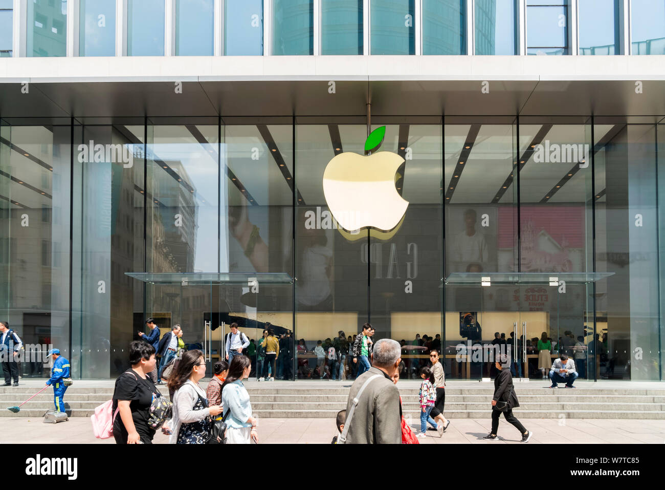 --FILE--Pedestrians walk past an Apple Store with the leaf of the logo ...