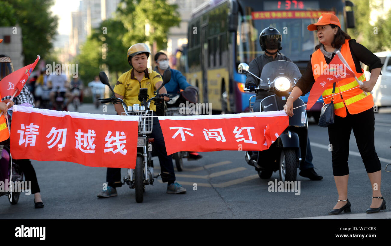 Chinese volunteers working as traffic order assistants use banners to ...