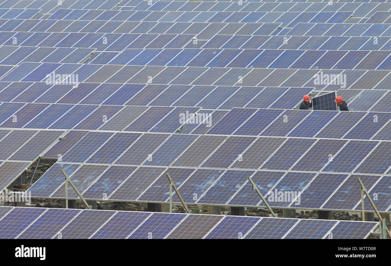 --FILE--Chinese workers install solar panels at a photovoltaic power ...
