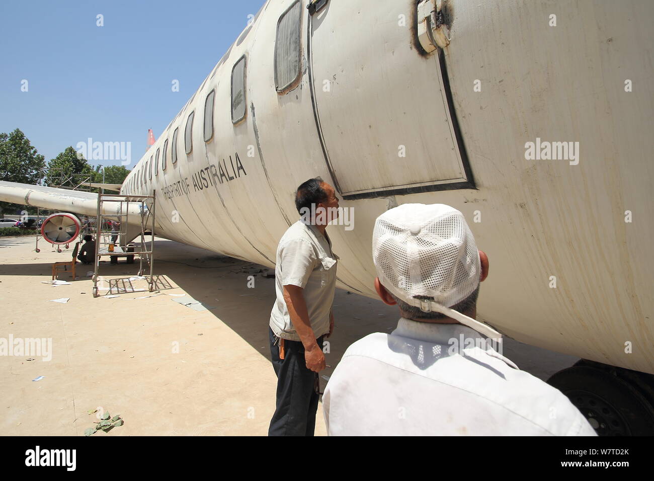 An elderly man looks at an old plane with "Boeing 767" and "QANTAS" on ...
