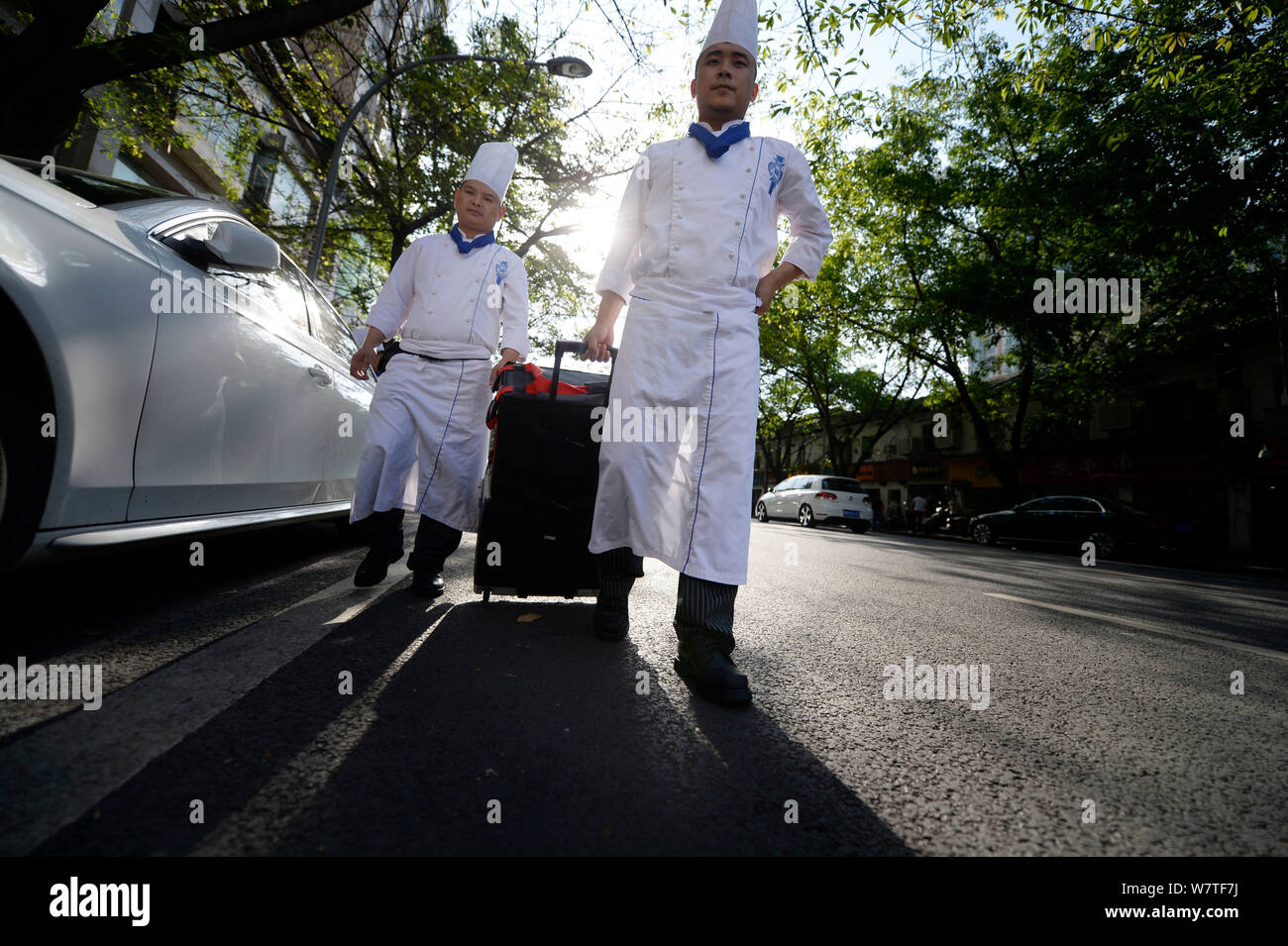 Chefs from a private kitchen platform walk to a customer's home with ...