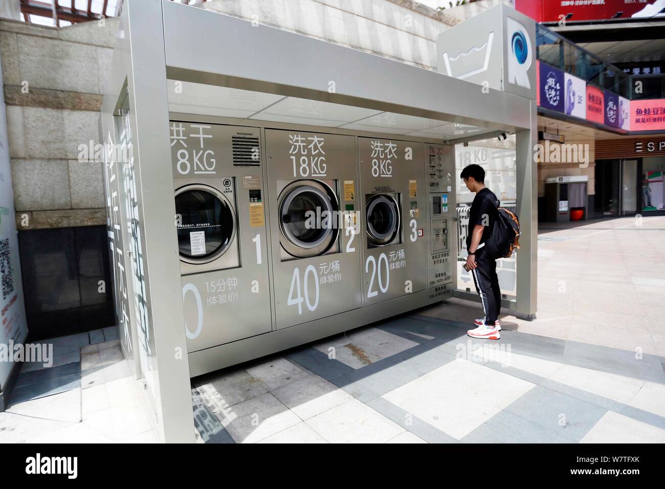 A customer looks at public washing machines installed outside a mall in ...