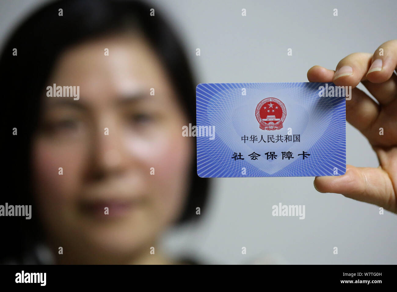--FILE--A Chinese resident shows her social security card in Huaian ...