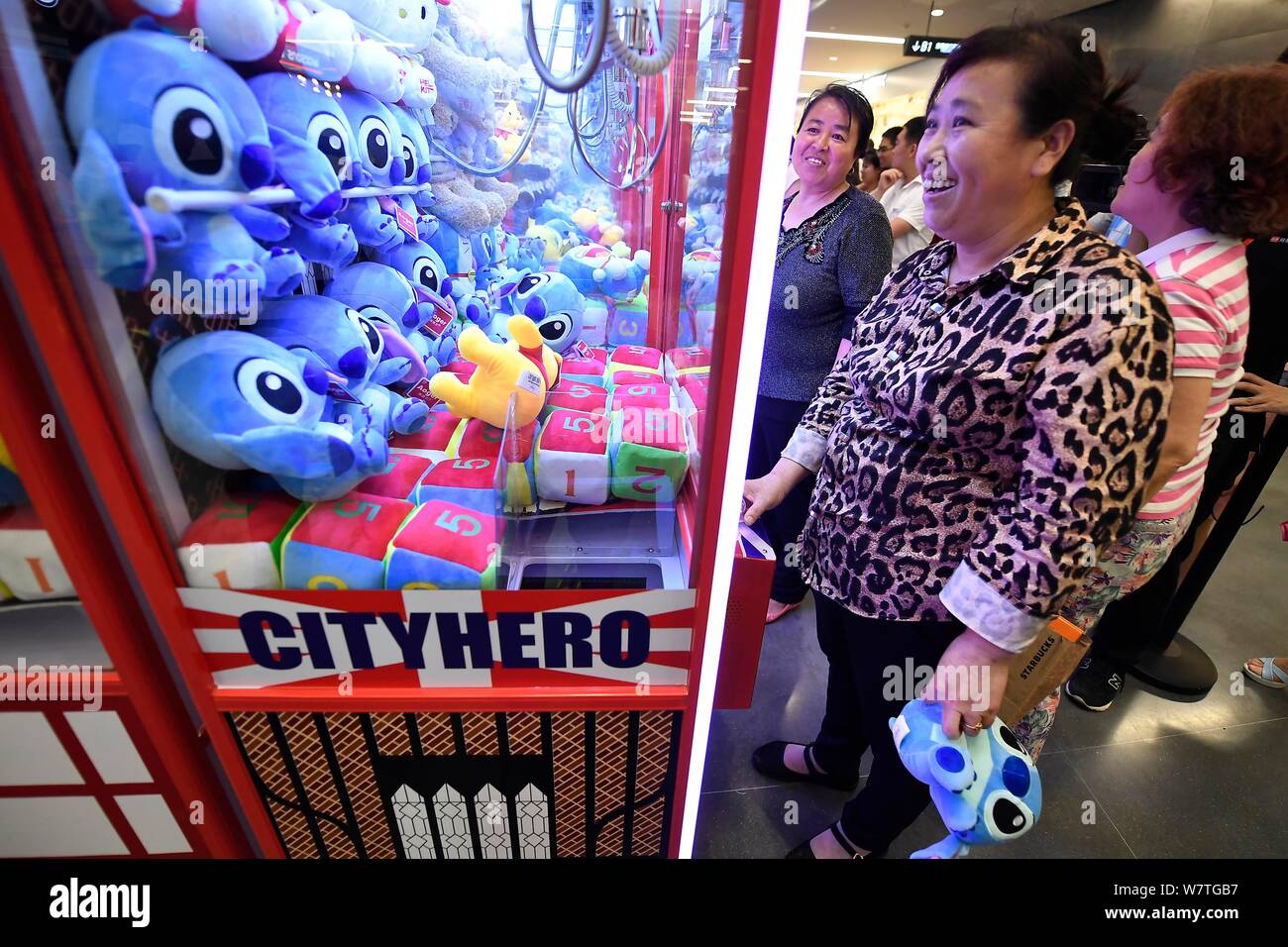 Competitors take part in a doll-grabbing competition at N1 shopping ...