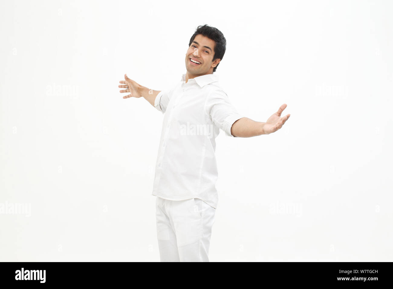 Young man smiling with his arm outstretched Stock Photo - Alamy