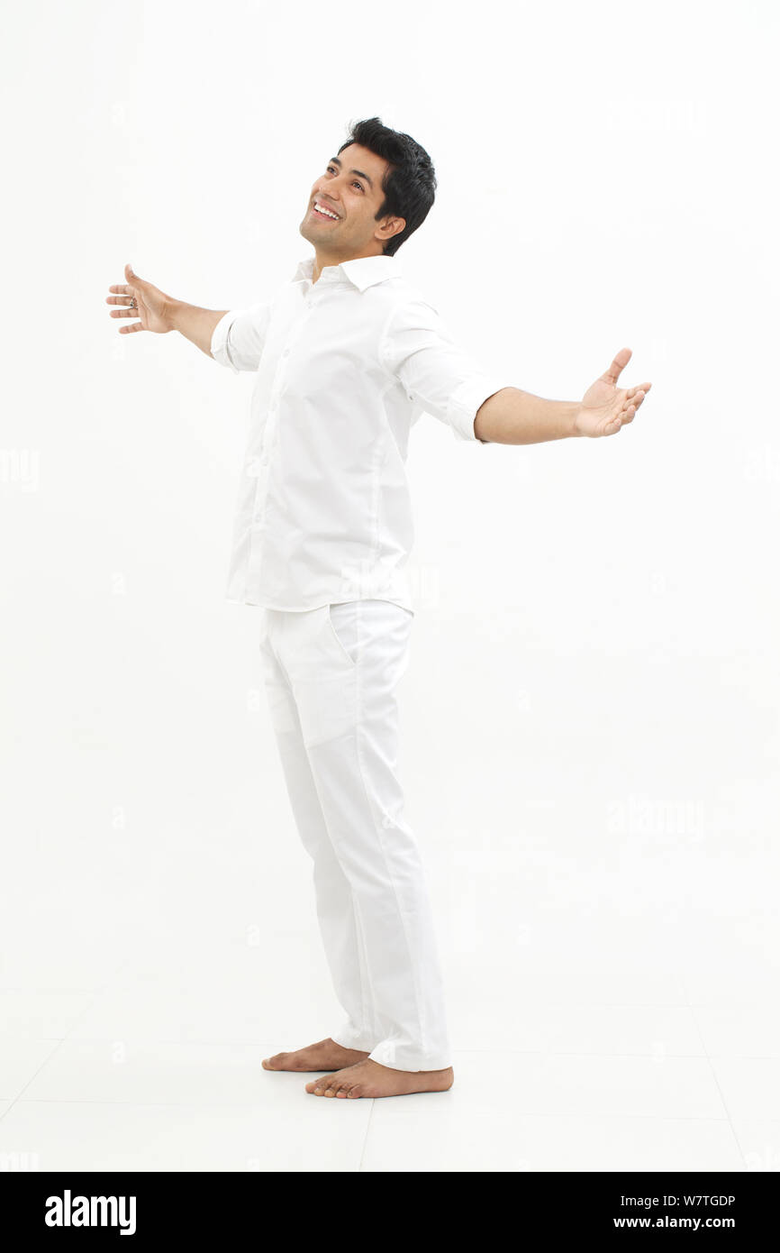 Young man smiling with his arm outstretched Stock Photo - Alamy