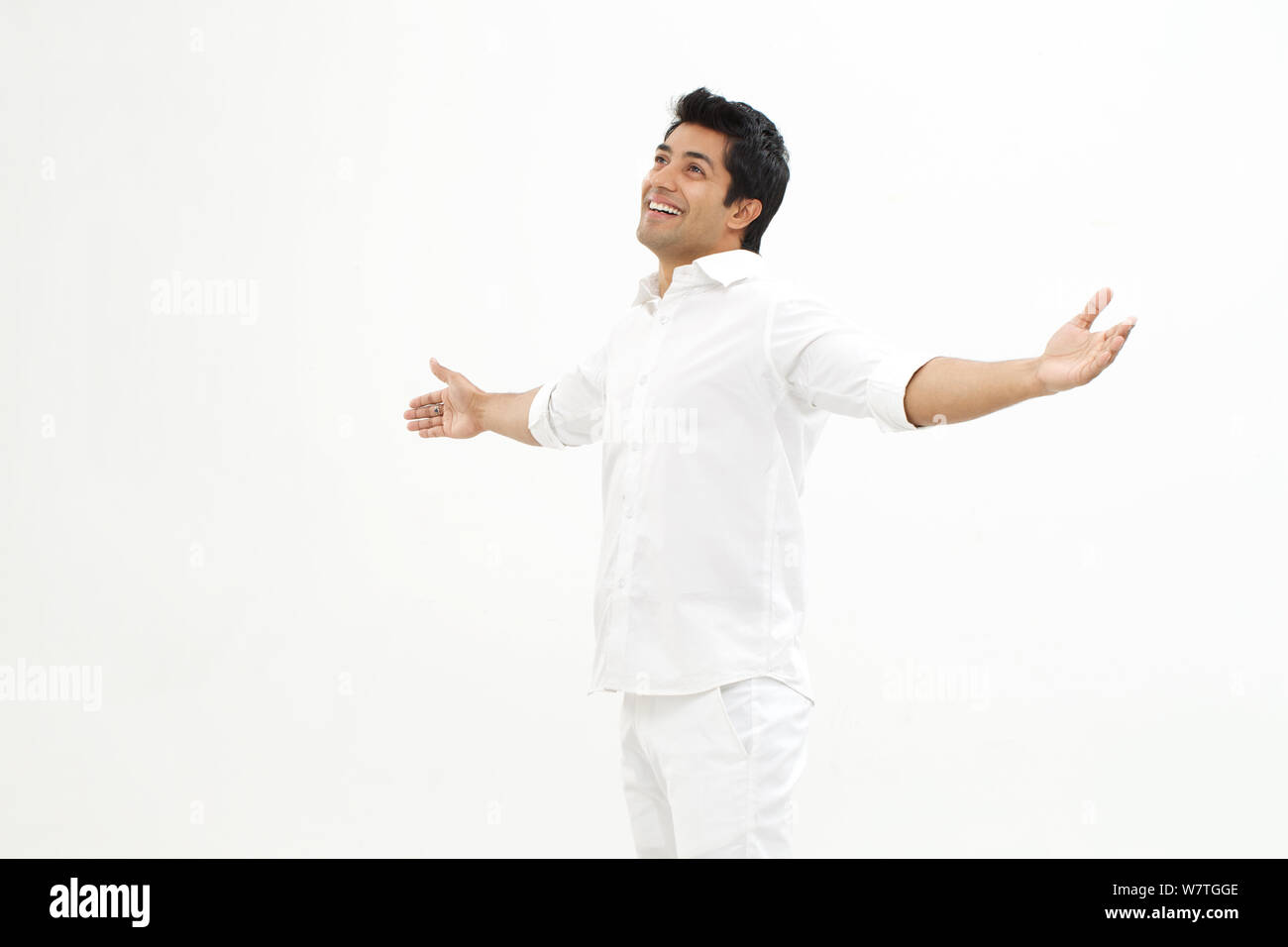 Young man smiling with his arm outstretched Stock Photo - Alamy