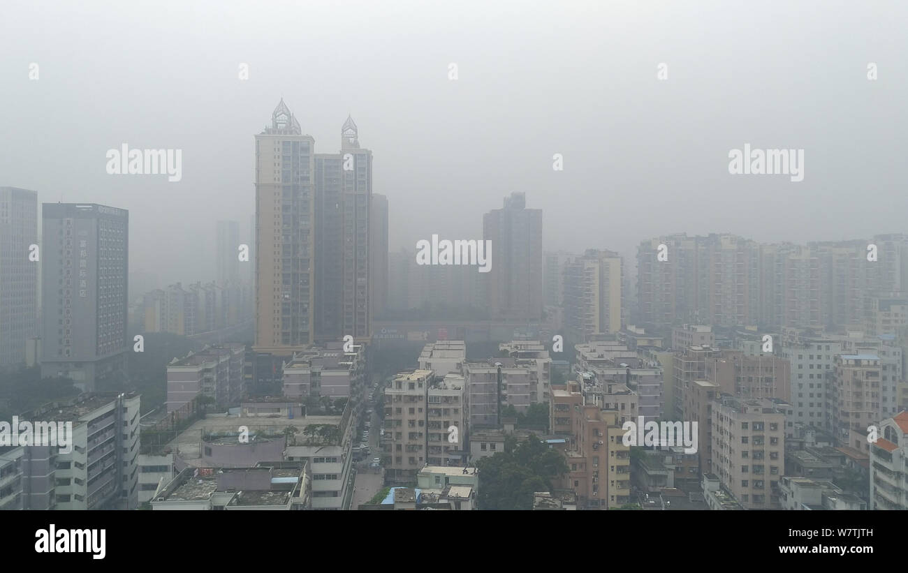 High-rise buildings and skyscrapers are seen vaguely in heavy smog in ...