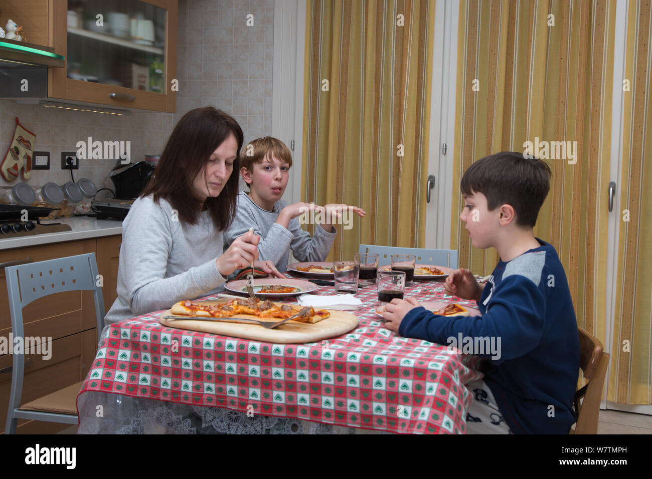 Family of Four People Eating Pizza on the Kitchen Table at Home Stock ...
