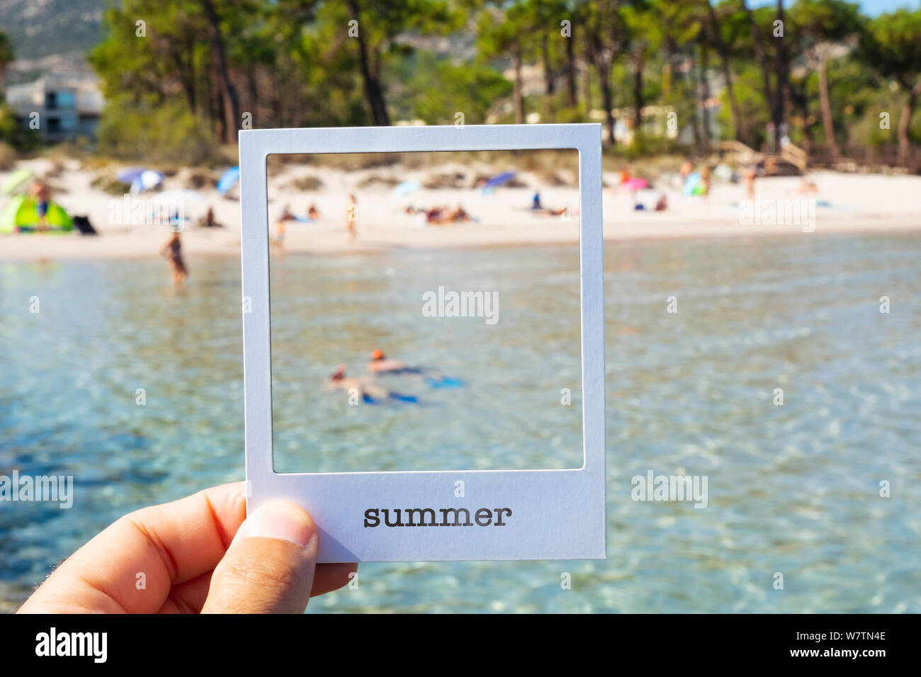 closeup of a man holding a white paperboard frame, with the word summer ...