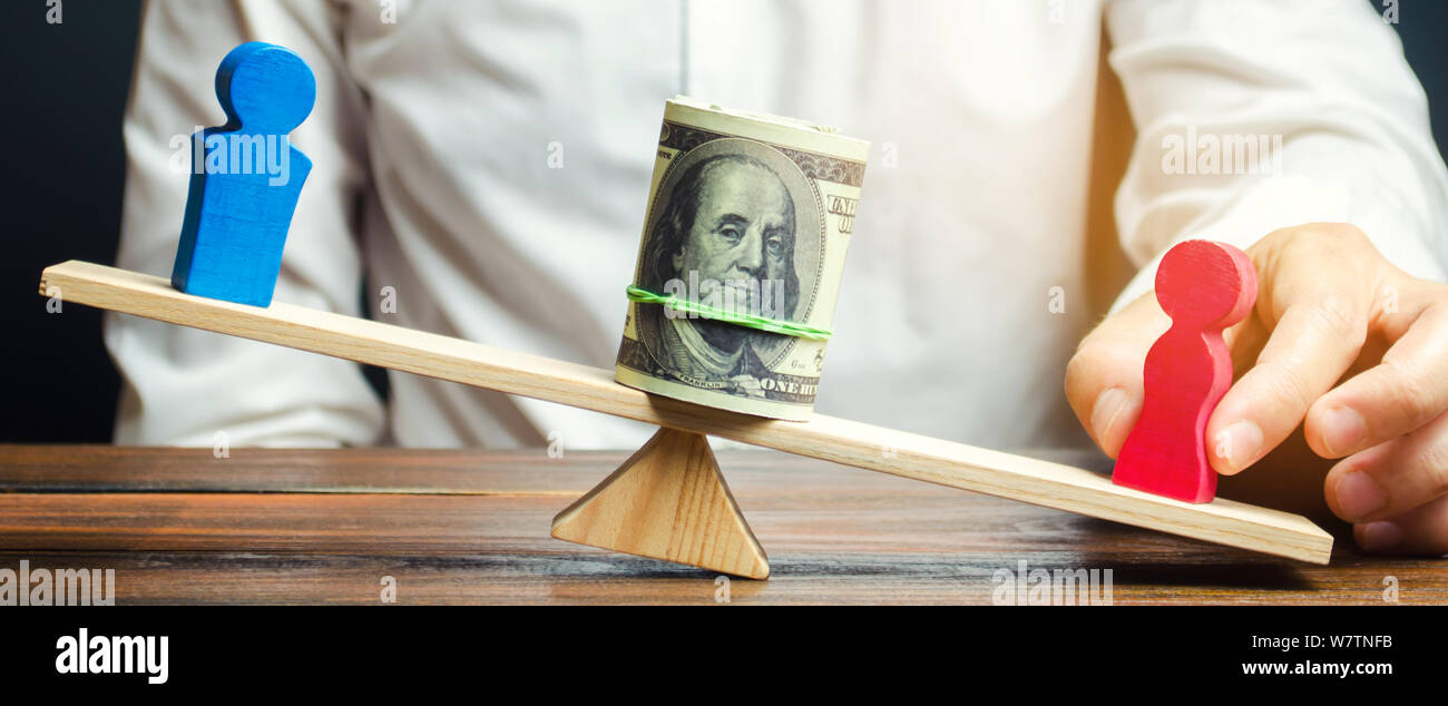 Wooden figures of man and women on the scales. Concept of gender pay ...