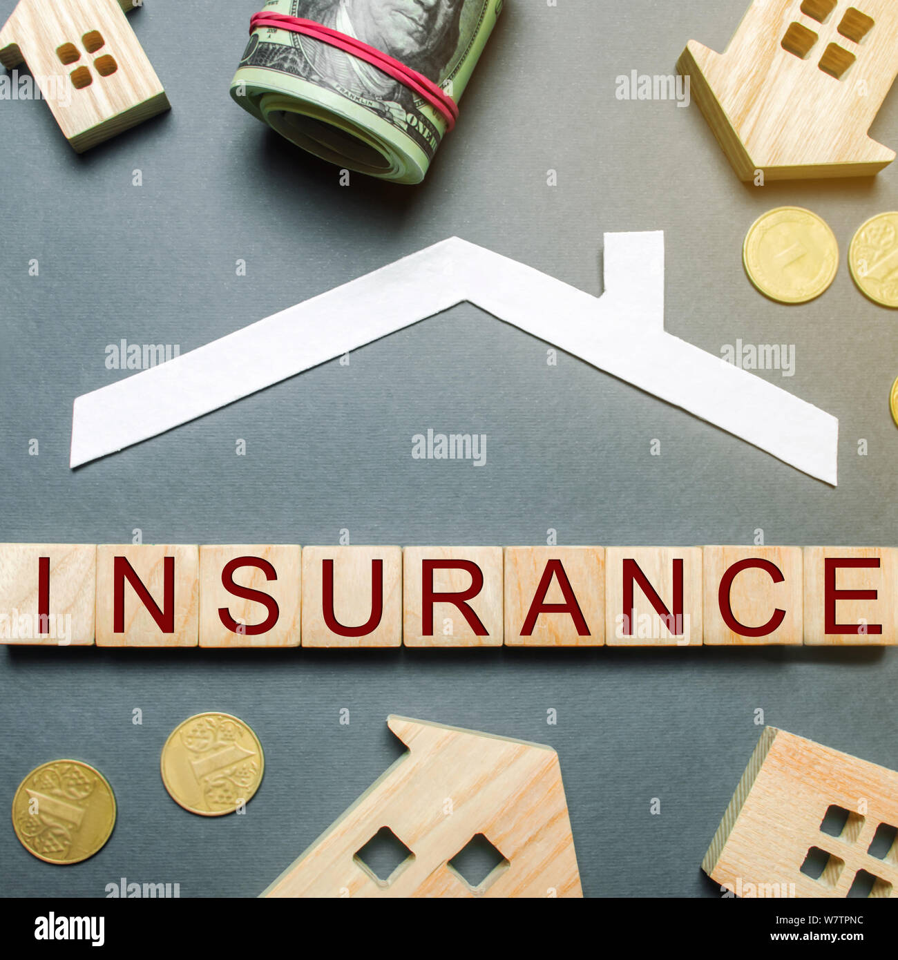 Table with wooden houses, calculator, coins, magnifying glass with the ...