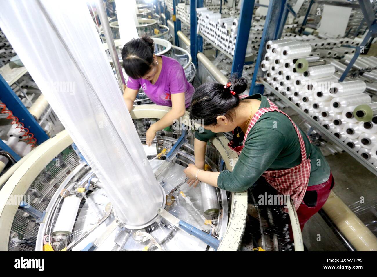 Female Chinese workers handle production of yarn at a textile factory in Huaian city, east China ...