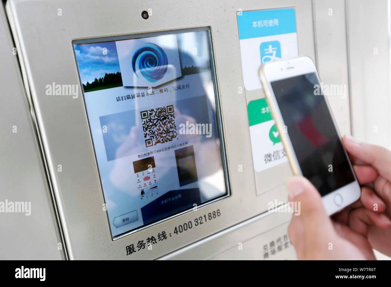 A customer uses his smartphone to scan a QR code via Alipay of Alibaba ...