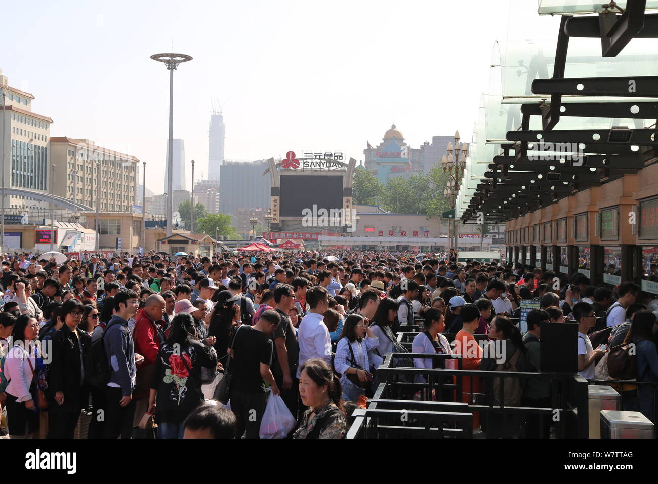 Crowds of passengers queue up to buy tickets on the square of the ...
