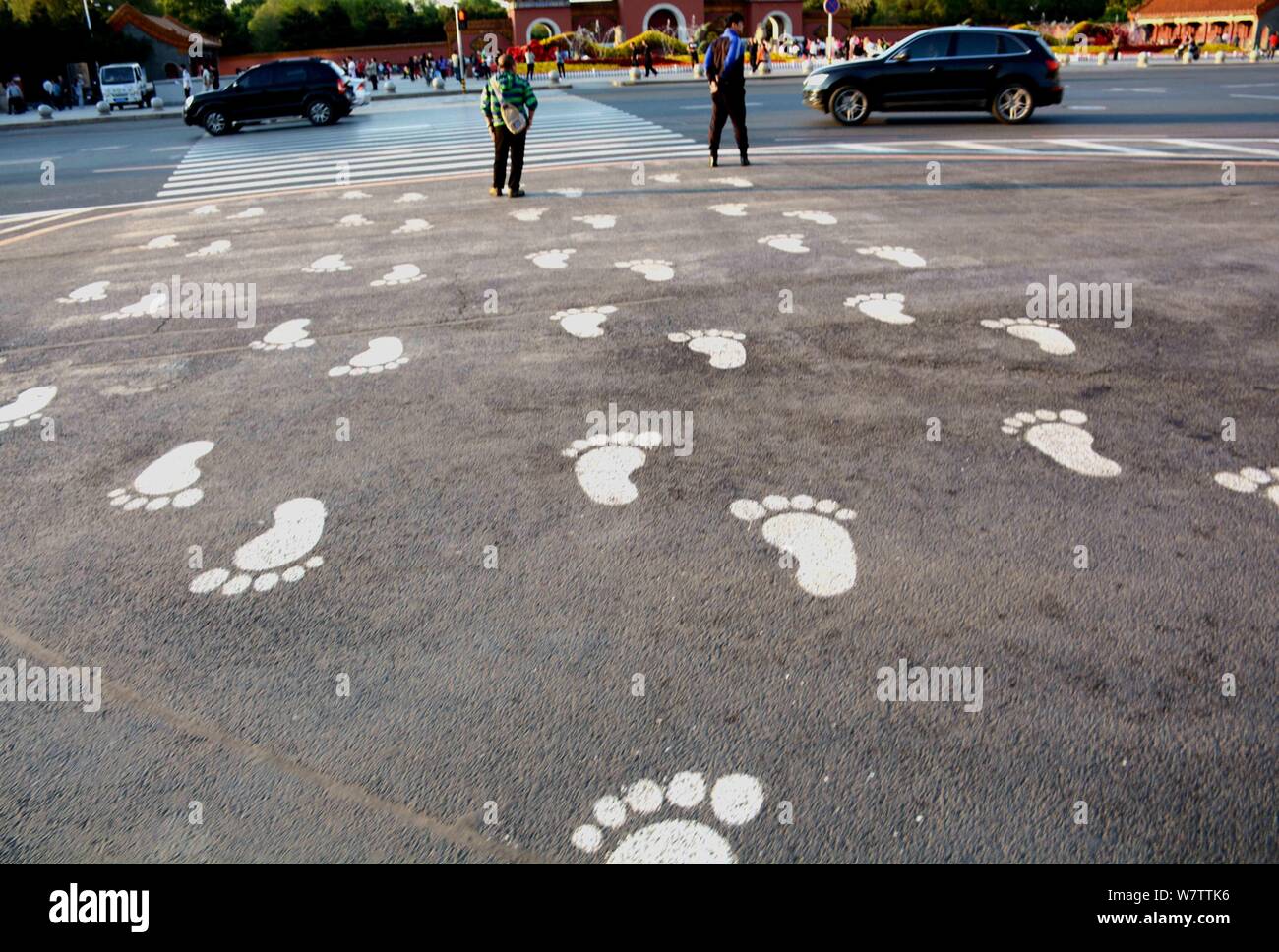 Local residents walk on the pedestrian crossing featuring numerous ...