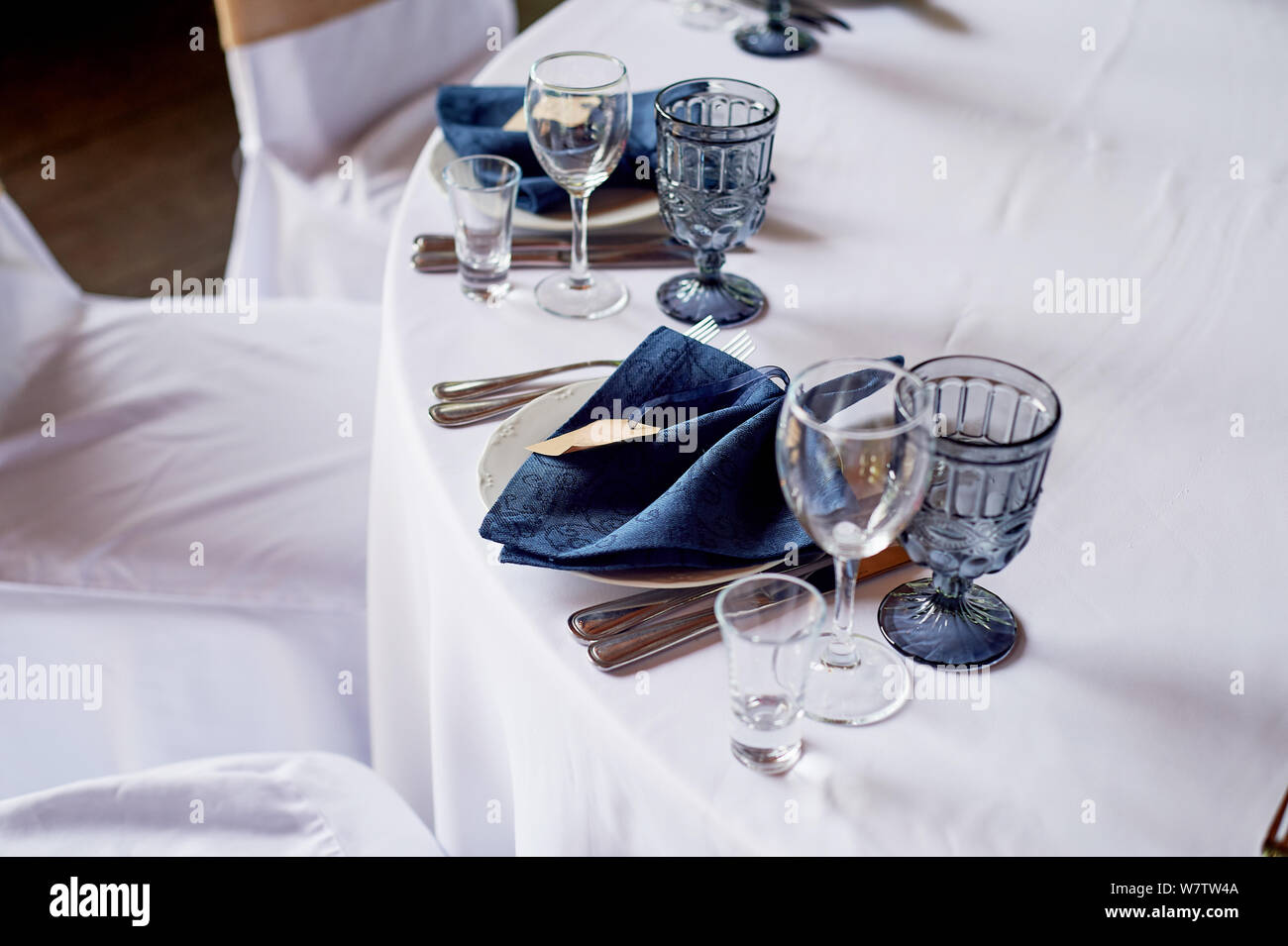 Classic table setting.Blue napkin and glasses. Banquet Stock Photo - Alamy