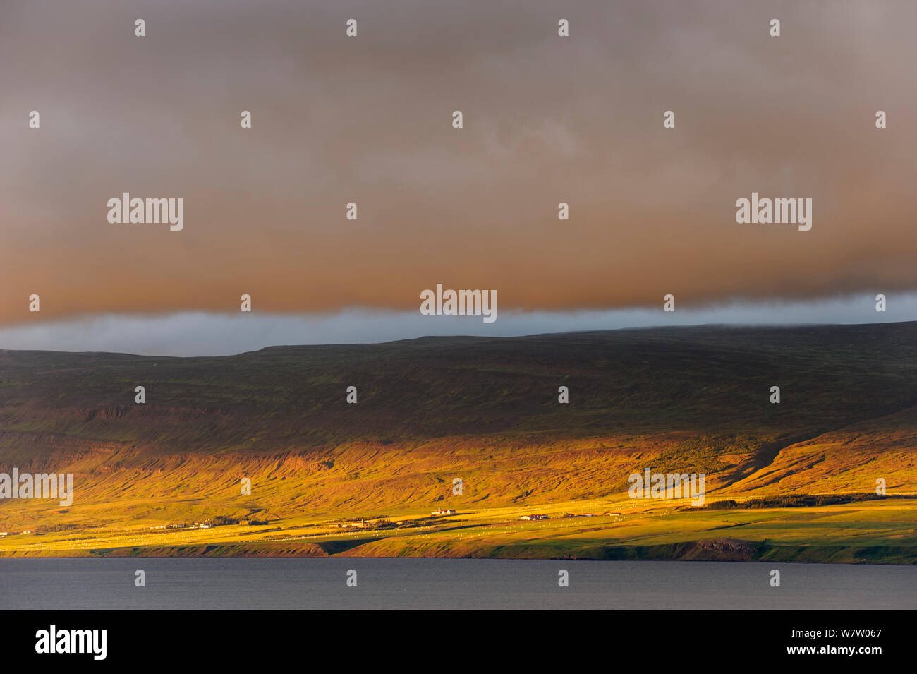 Dark cloud casting shadow on hill, sunshine below, Westfjords, Iceland ...