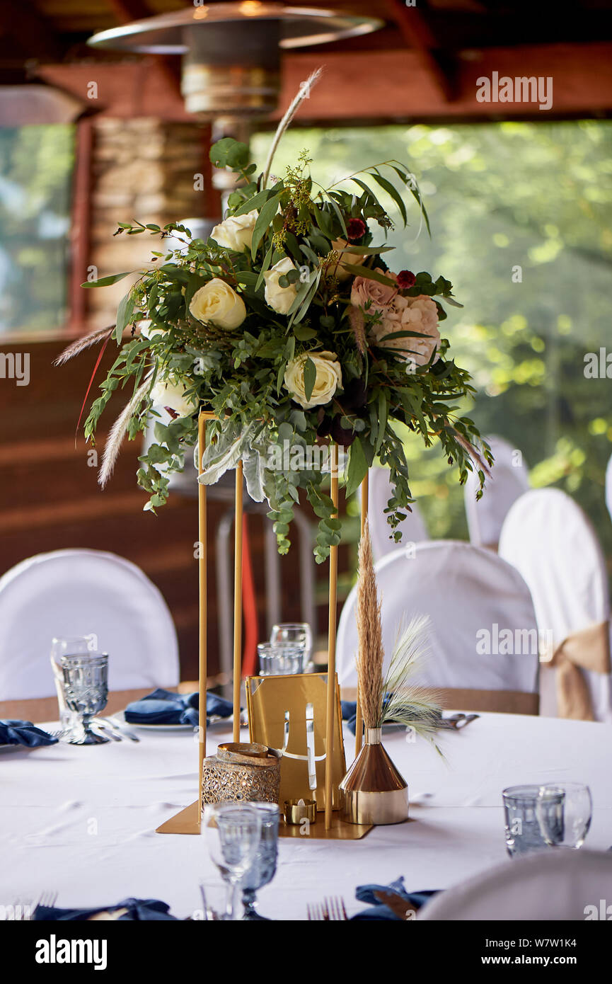 Stand metal thin with floral arrangement.And table number. Wedding ...