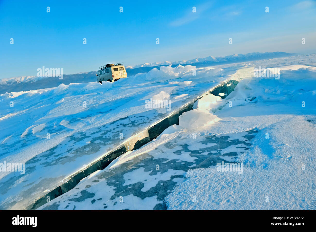 Van on frozen Lake Baikal with cracked ice, Lake Baikal, Siberia ...