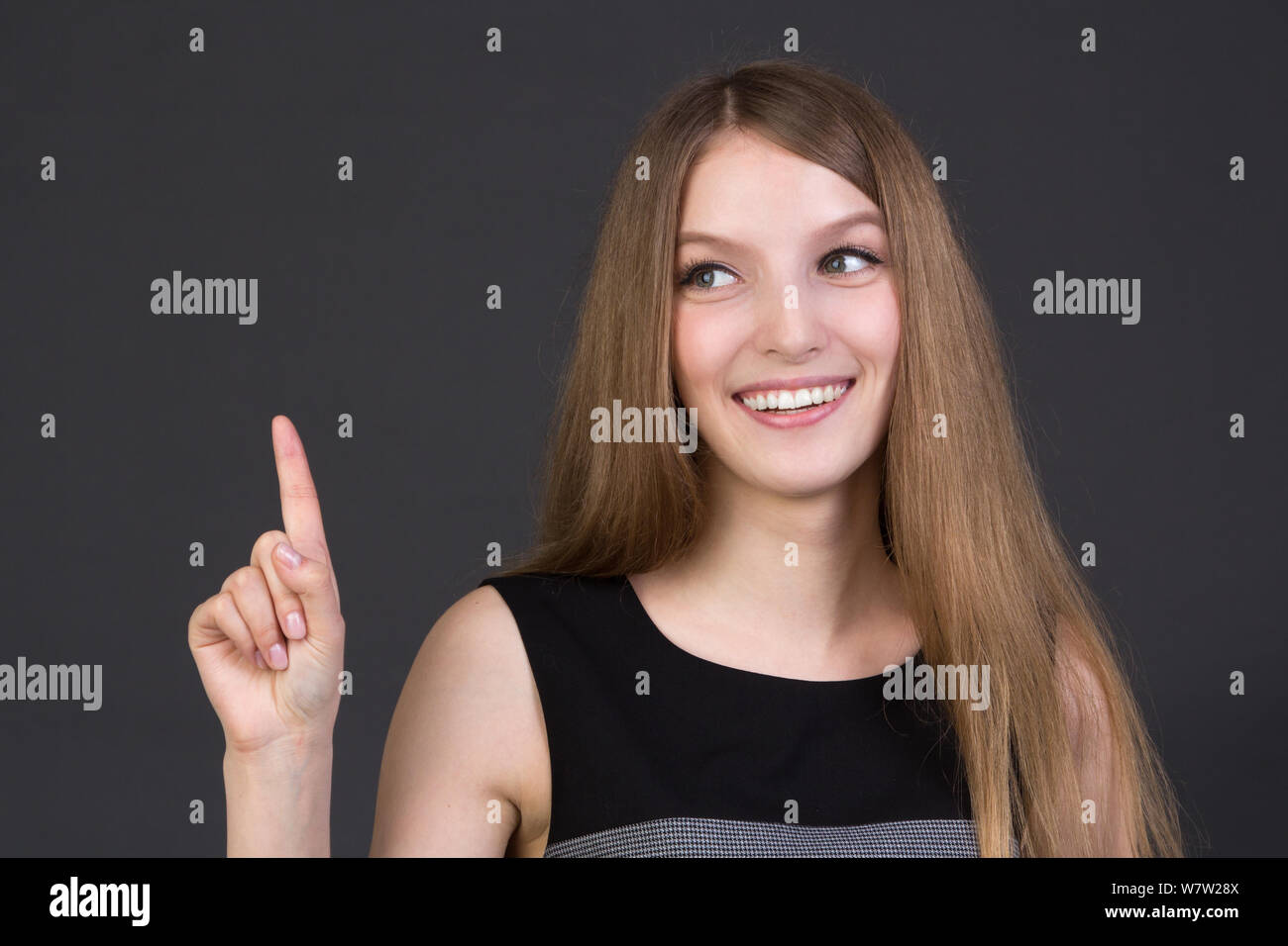 beautiful smiling girl holding forefinger up, studio picture Stock ...