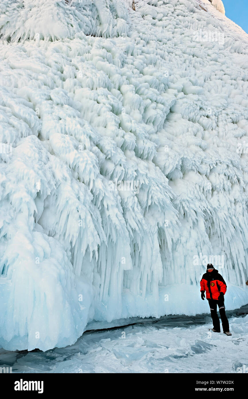 Ice formation caused by splashing water, with man standing underneath ...
