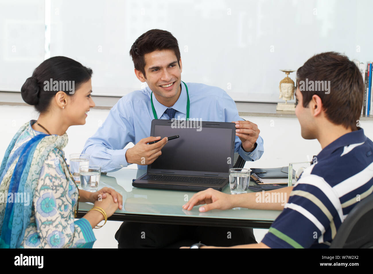 Real estate agent showing house plan on laptop Stock Photo - Alamy
