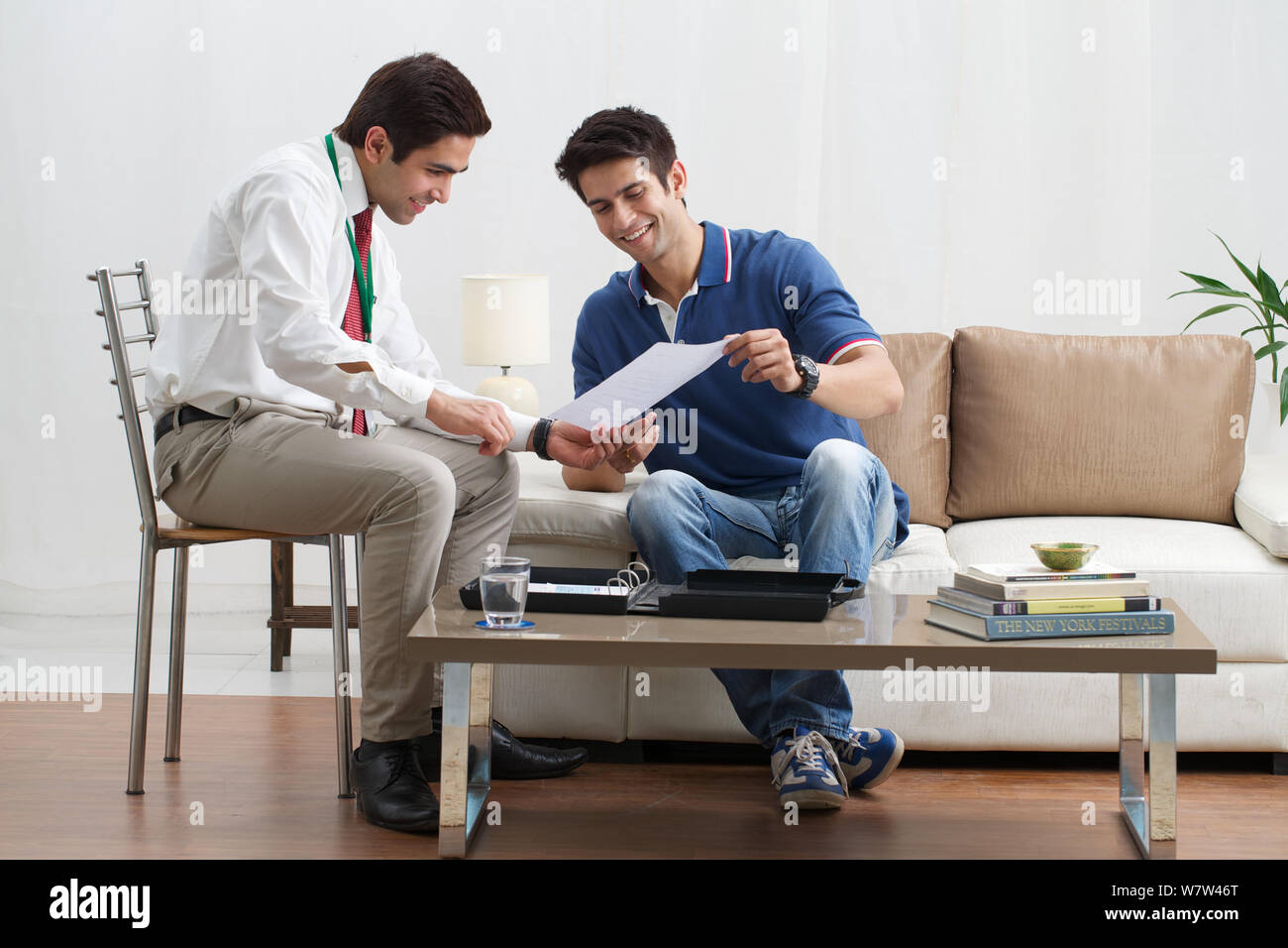 Financial advisor explaining on document to a client Stock Photo - Alamy