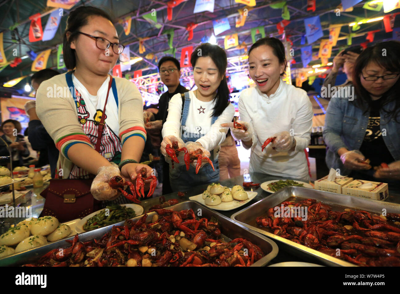 Chinese foodies eat crayfish during a feast held by a gourmet plaza to ...