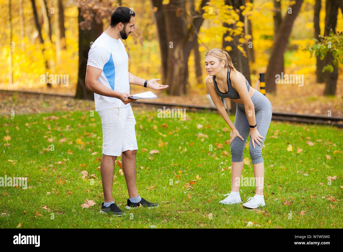 Male personal trainer showing results to her female client Stock Photo - Alamy