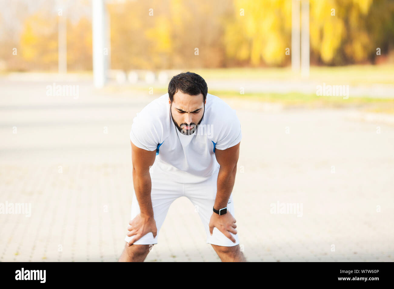 Fitness. Tired man runner rest after running on city stree Stock Photo ...