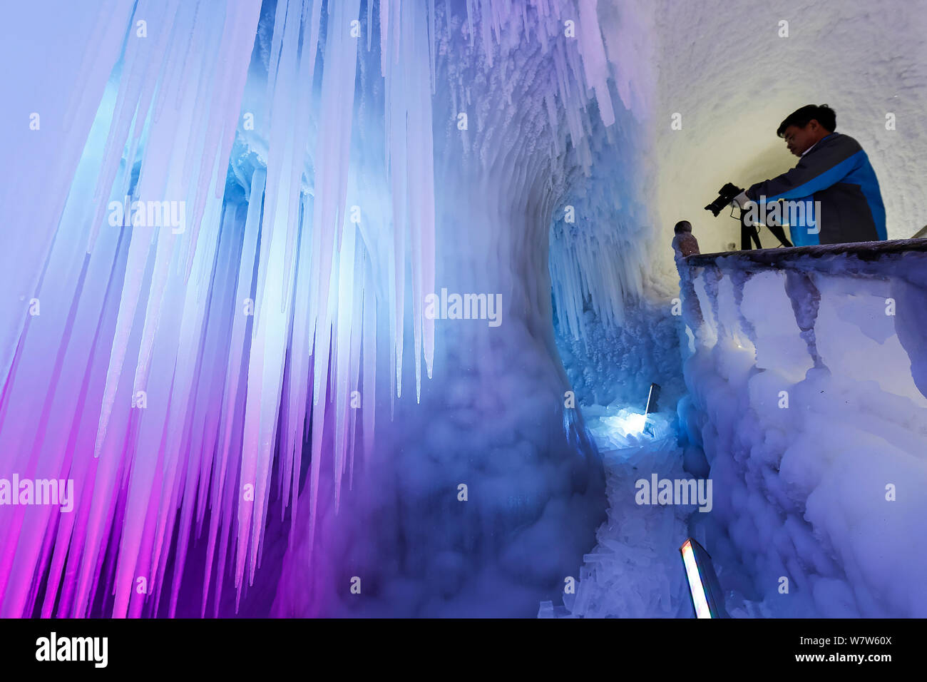 A photographer takes photos of the China's largest ice cave with ...