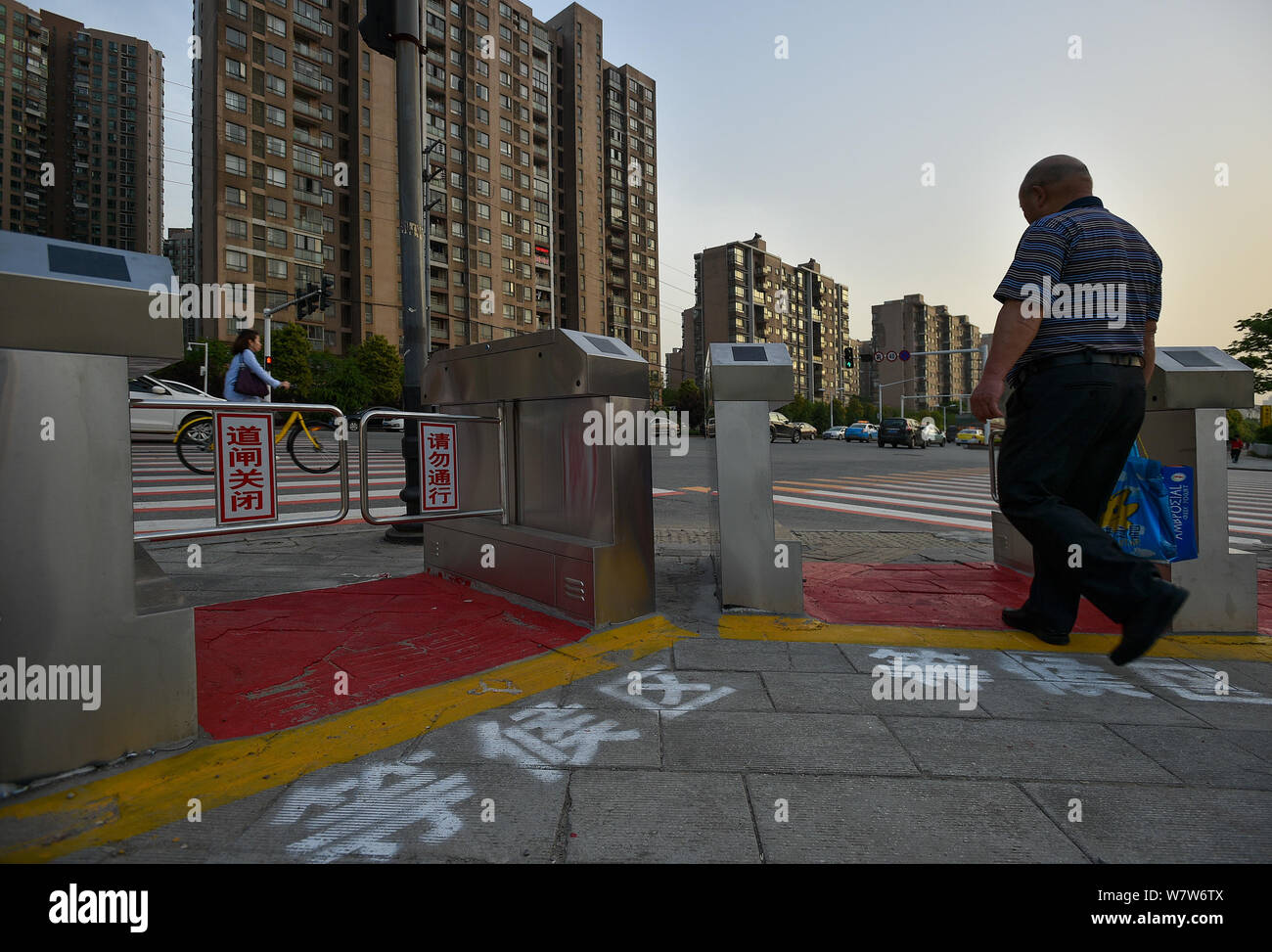 A pedestrian walks through newly installed crosswalk gates, which shut ...