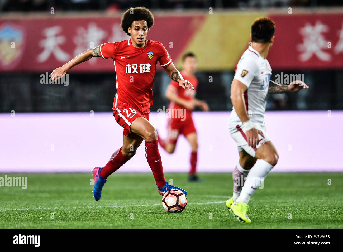 Belgian football player Axel Witsel of Tianjin Quanjian, left, kicks ...
