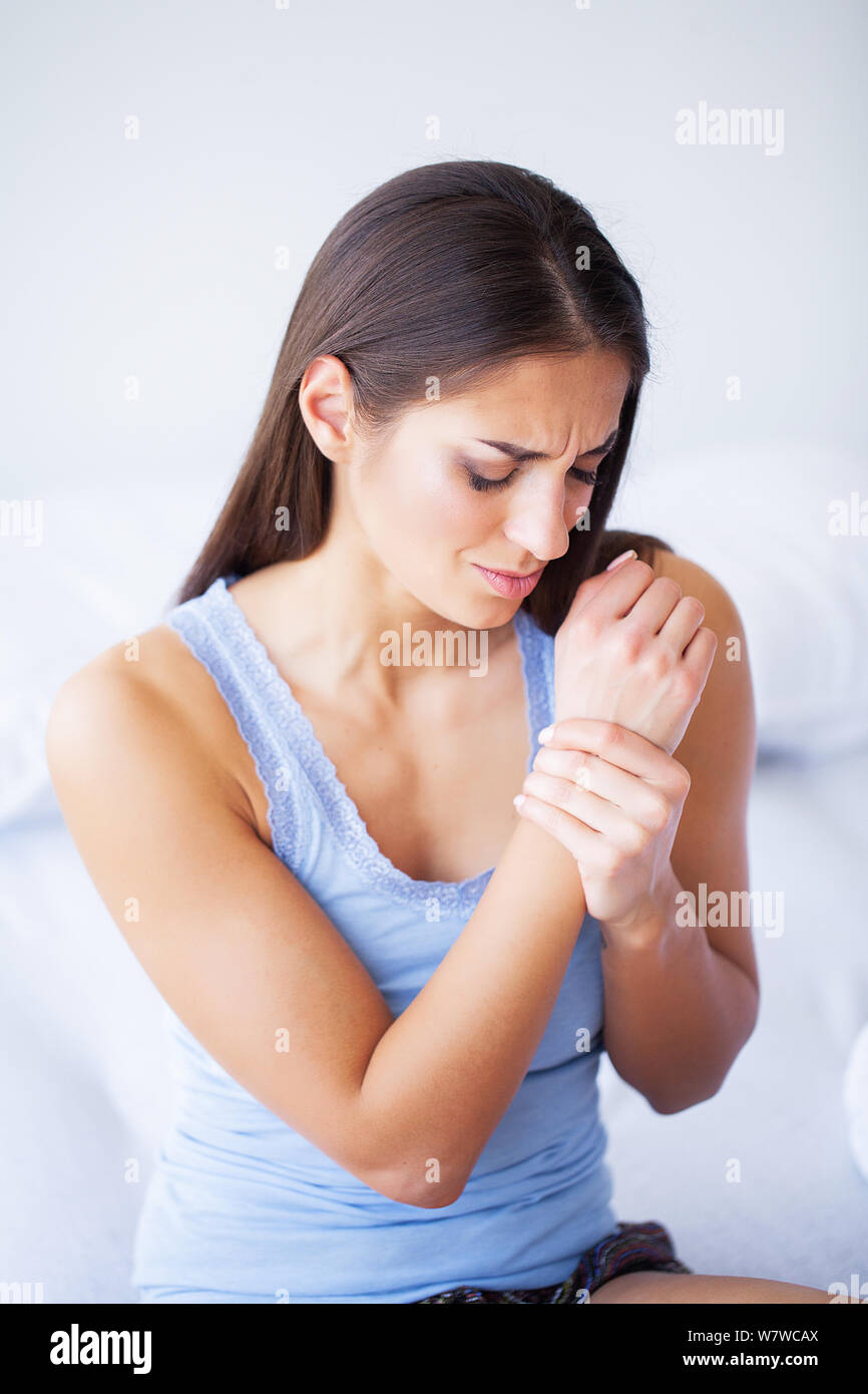 Pain hand. Sad woman with pain in hand at home Stock Photo - Alamy