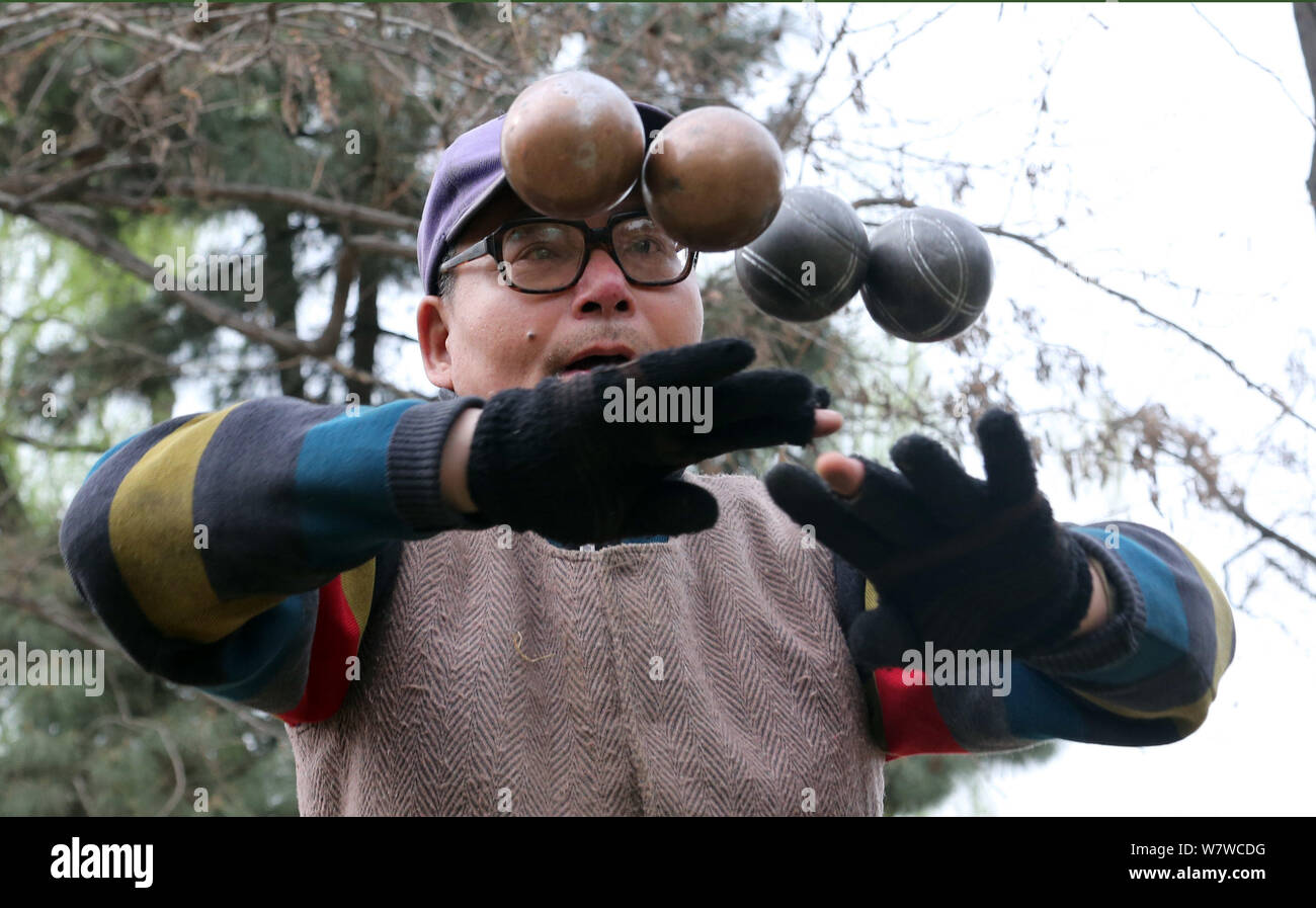 61-year-old Chinese man Piao Yingmin plays iron balls at a park in ...