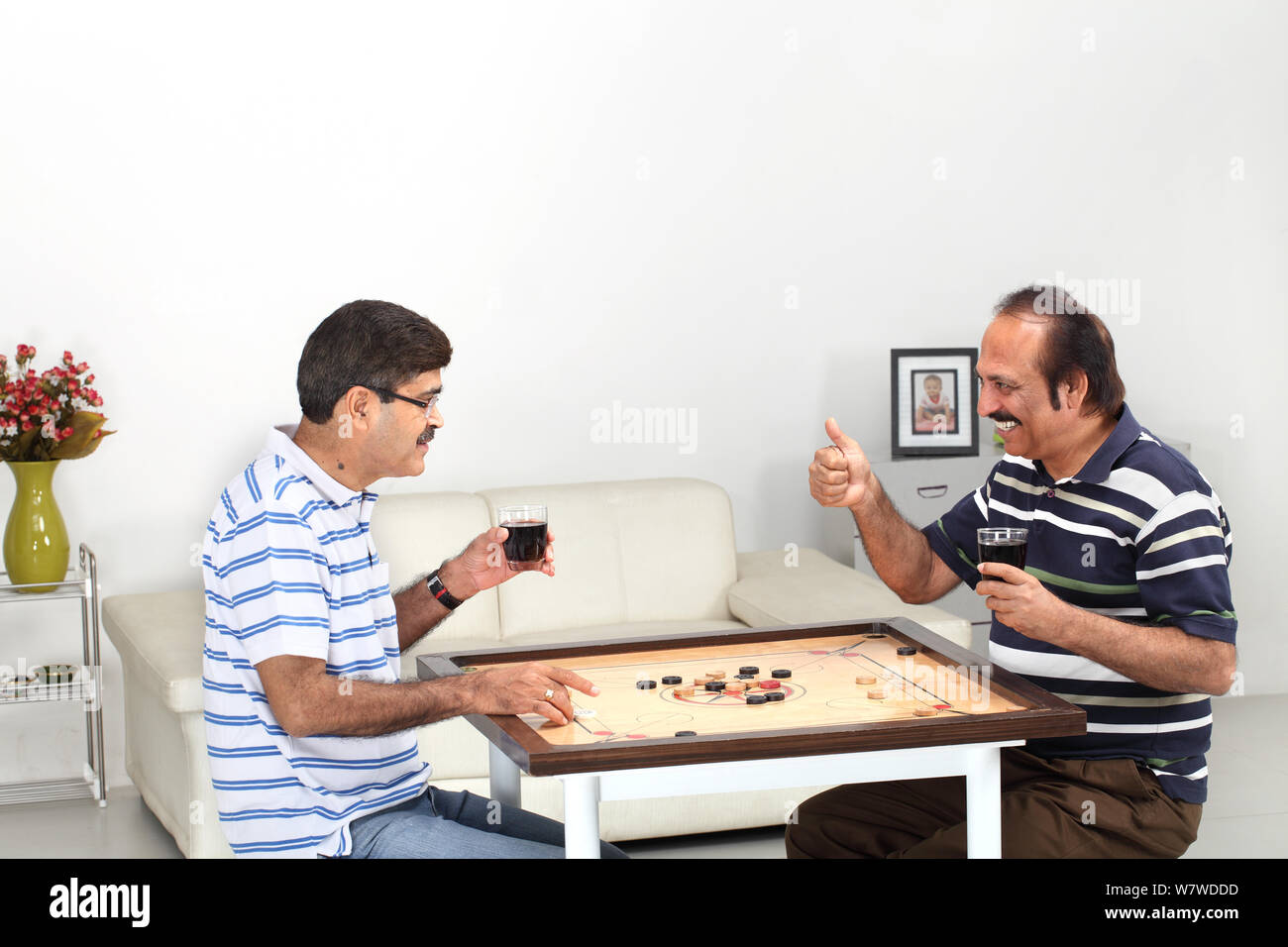 Two friends playing carom at home Stock Photo - Alamy