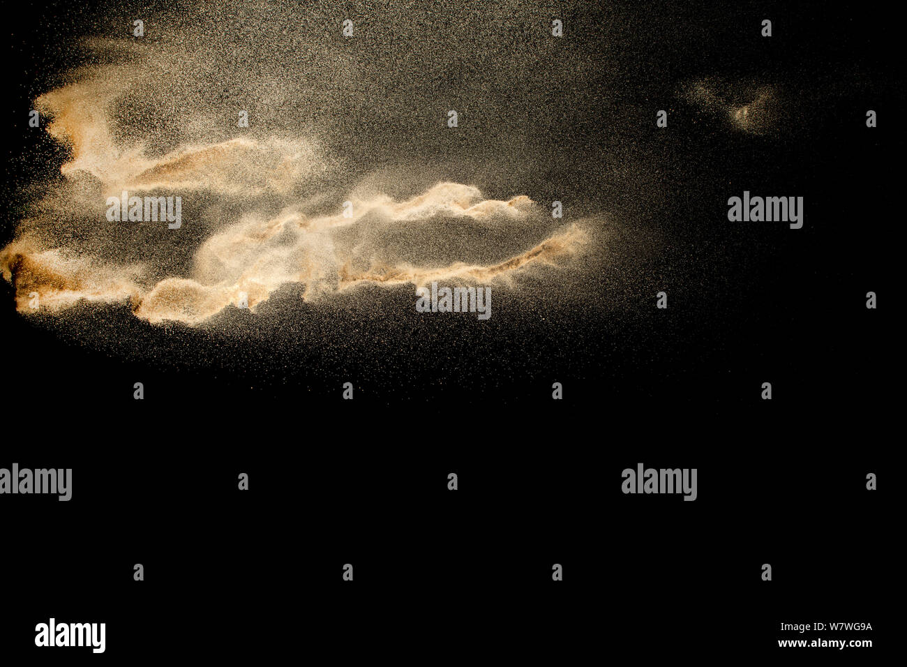 Brown colored sand splash against dark background. Dry river sand ...