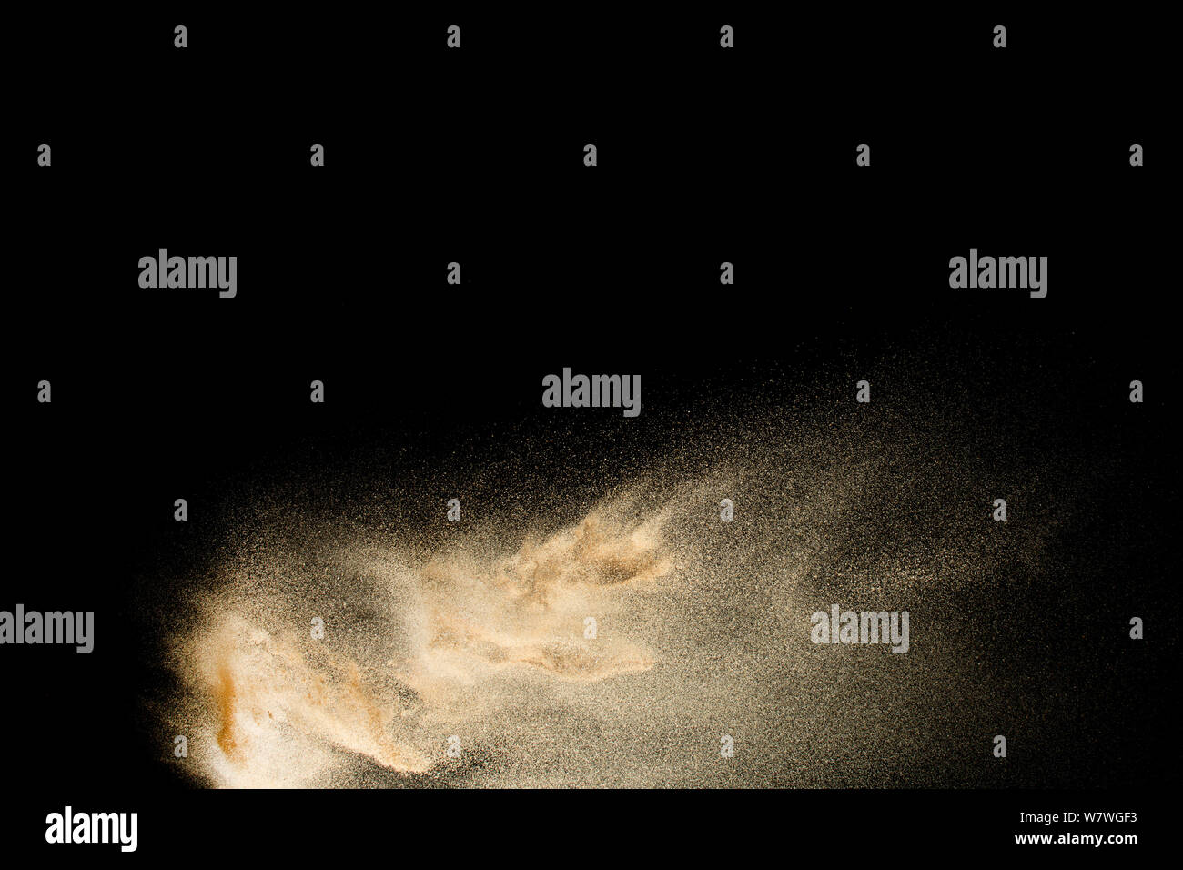 Brown colored sand splash against dark background. Dry river sand ...