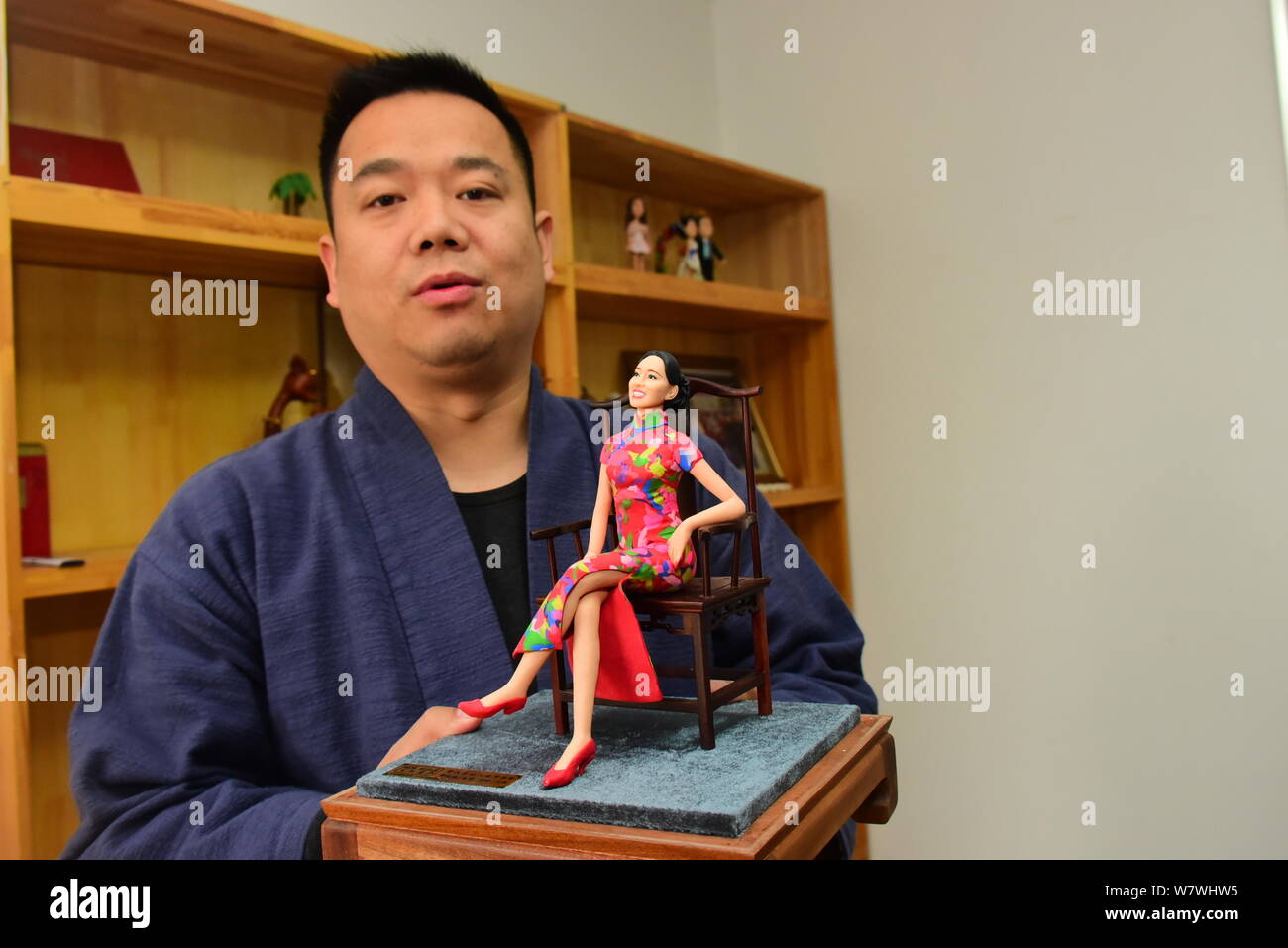 Chinese craftsman Jia Guanghui shows a clay figure of a woman dressed ...