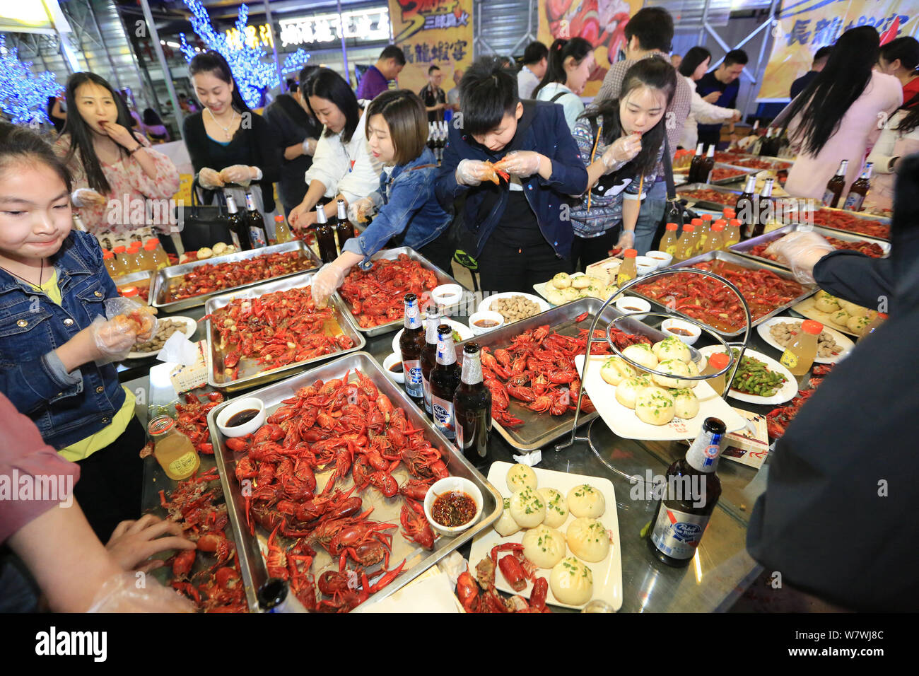 Chinese foodies eat crayfish during a feast held by a gourmet plaza to ...