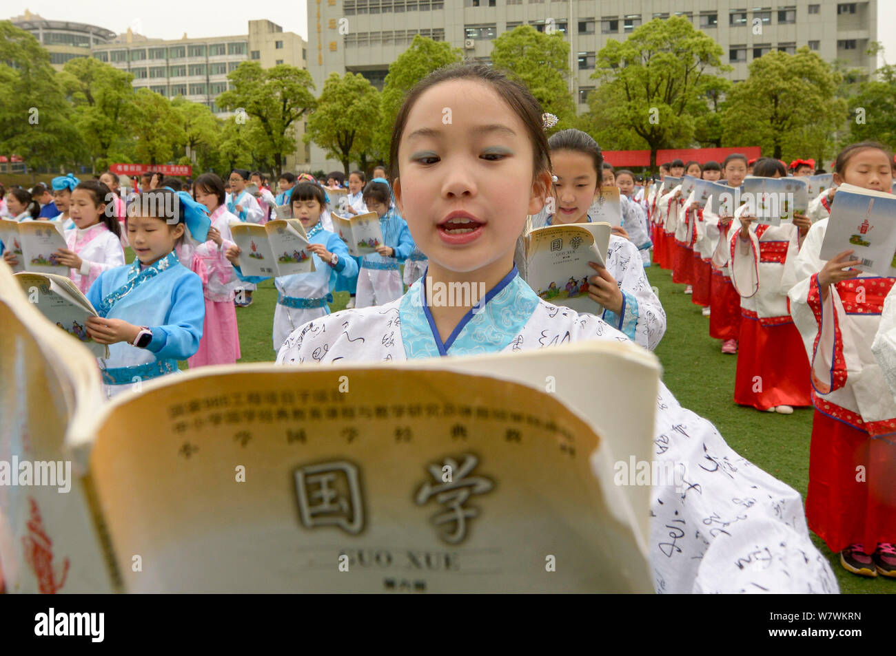 Chinese students dressed in traditional costumes read Chinese classics ...