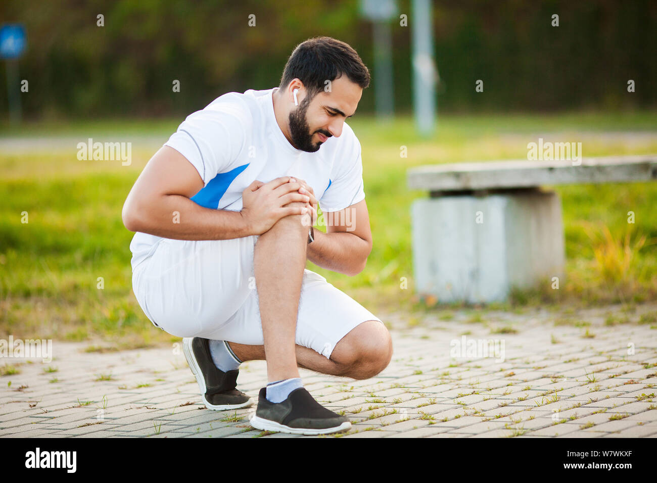 Leg Injury. Male athlete suffering from pain in leg while exercising ...