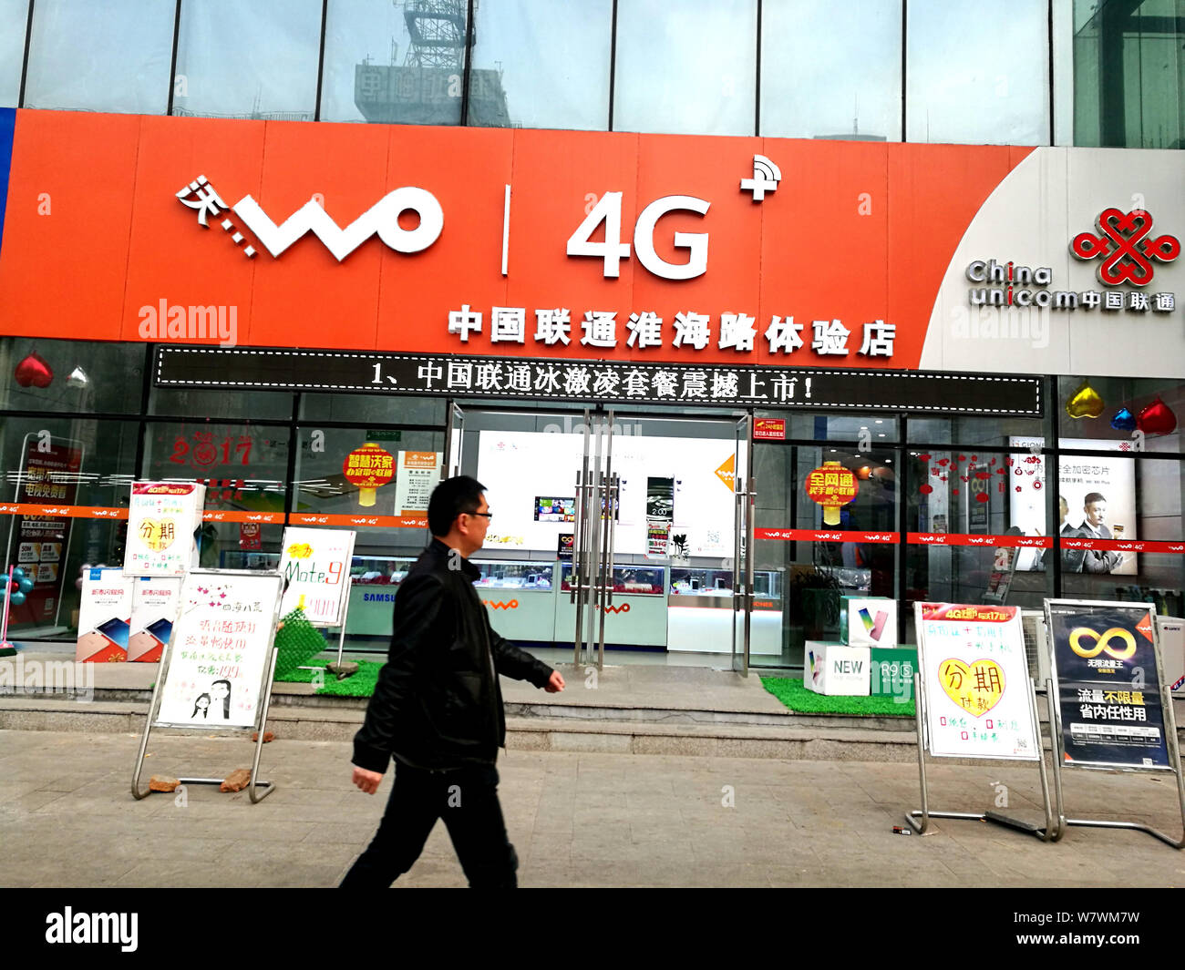 --FILE--A pedestrian walks past a branch of China Unicom in Huaibei ...