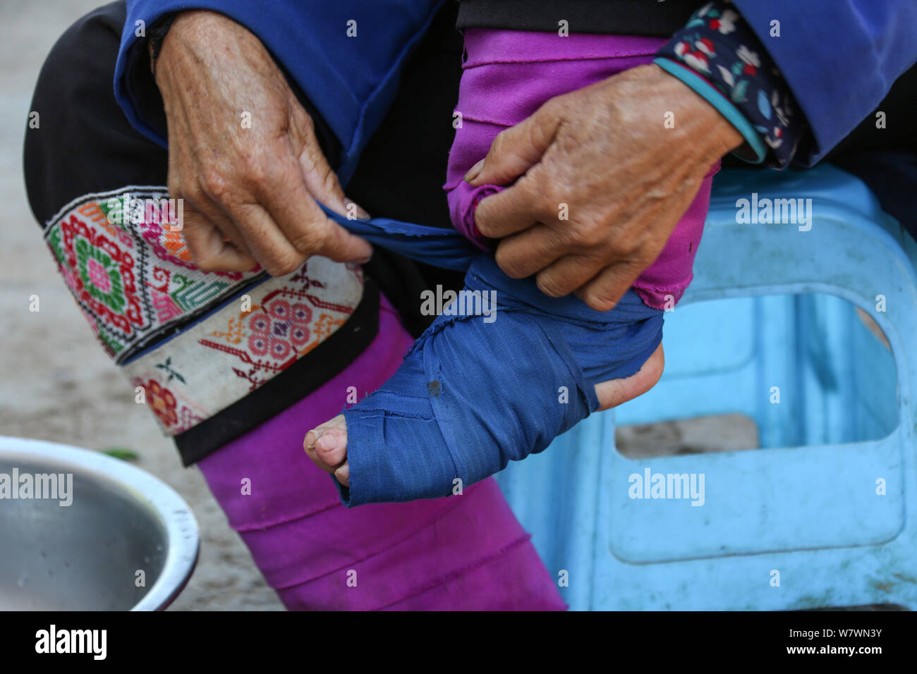 An elderly Chinese woman washes her bound feet in Weining Yi, Hui, and ...