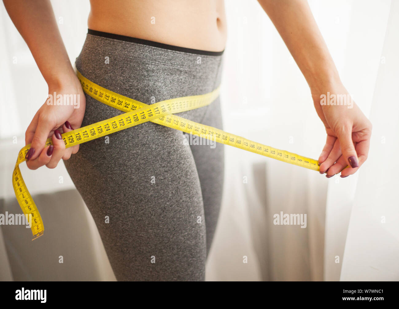 Slim young woman measuring her thin waist with a tape measure Stock ...